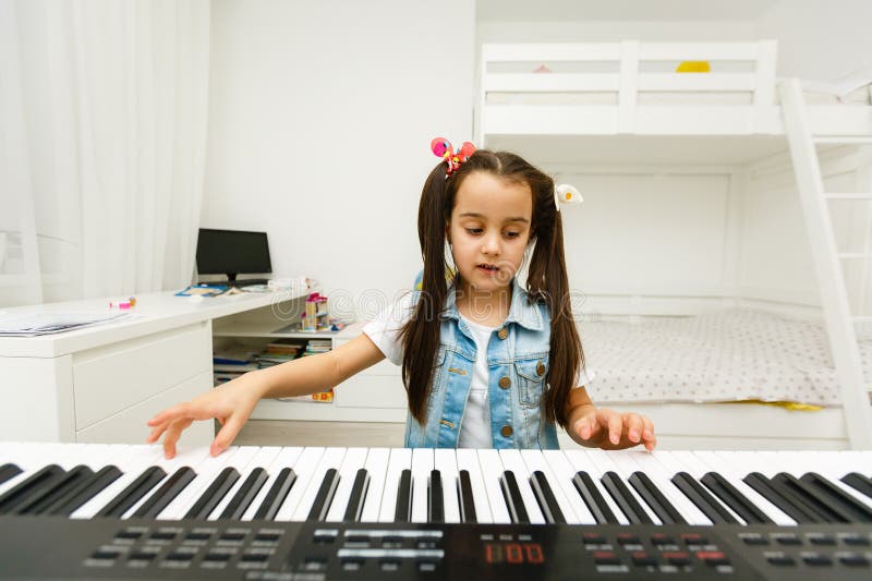 A Cute Little Girl Learning To Play the Synthesizer. Stock Photo ...