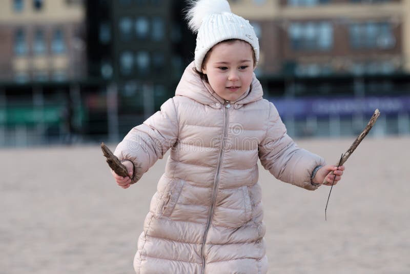 Cute Little Girl is Playing on an Empty Beach on a Cold Day Stock Image ...