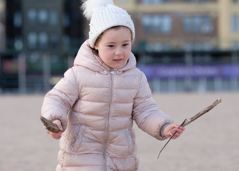 Cute Little Girl is Playing on an Empty Beach on a Cold Day Stock Photo ...