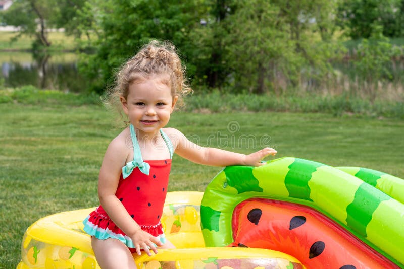 Cute Little Girl Playing in an Inflatable Pool in the Backyard Stock ...