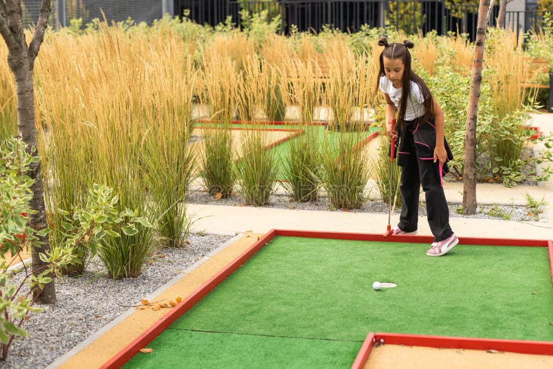 Cute Little Girl Playing Mini Golf in a Park. Stock Image - Image of ...