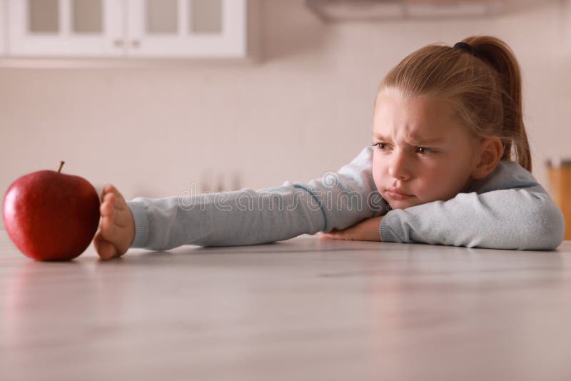 Cute Little Girl Refusing To Eat Apple in Kitchen Stock Image - Image ...
