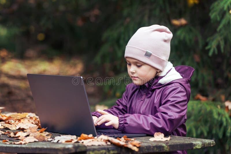 Cute Little Girl Using a Laptop Computer for Online Learning at an Old ...