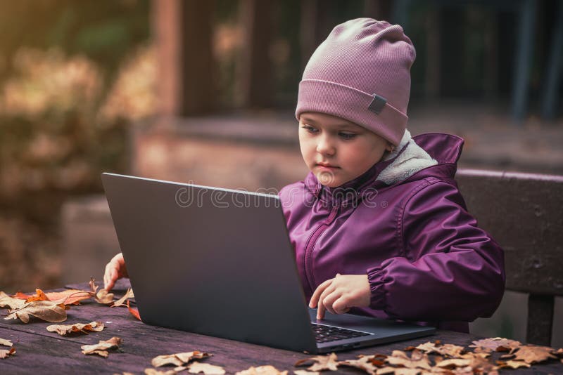 Cute Little Girl Using a Laptop Computer for Online Learning at an Old ...