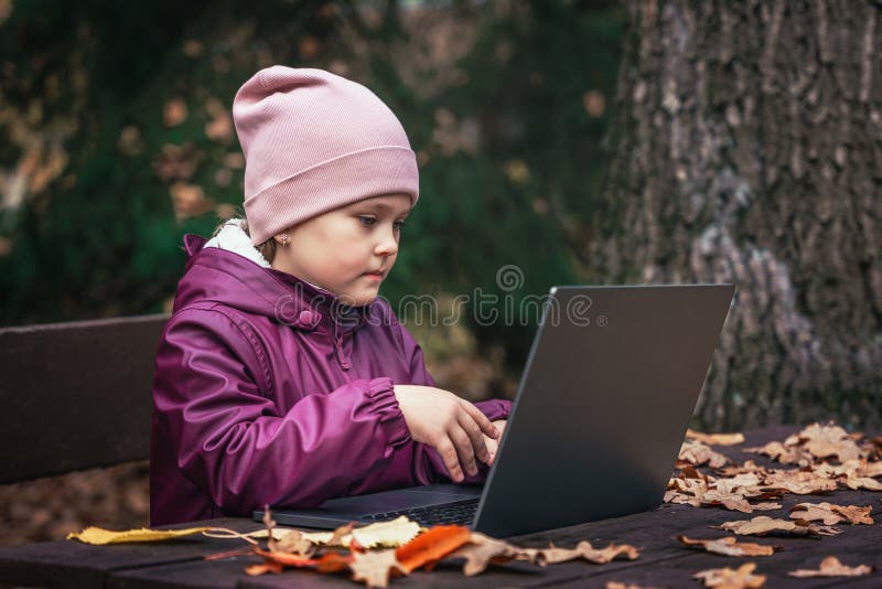 Cute Little Girl Using a Laptop Computer for Online Learning at an Old ...