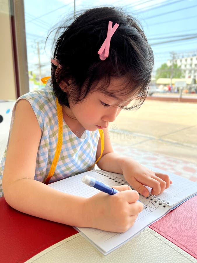 Cute Little Girl Writes on Her Notebook Stock Photo - Image of notebook ...