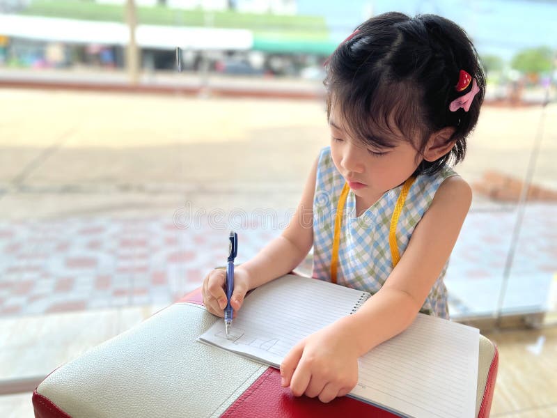 Cute Little Girl Writes on Her Notebook Stock Photo - Image of ...