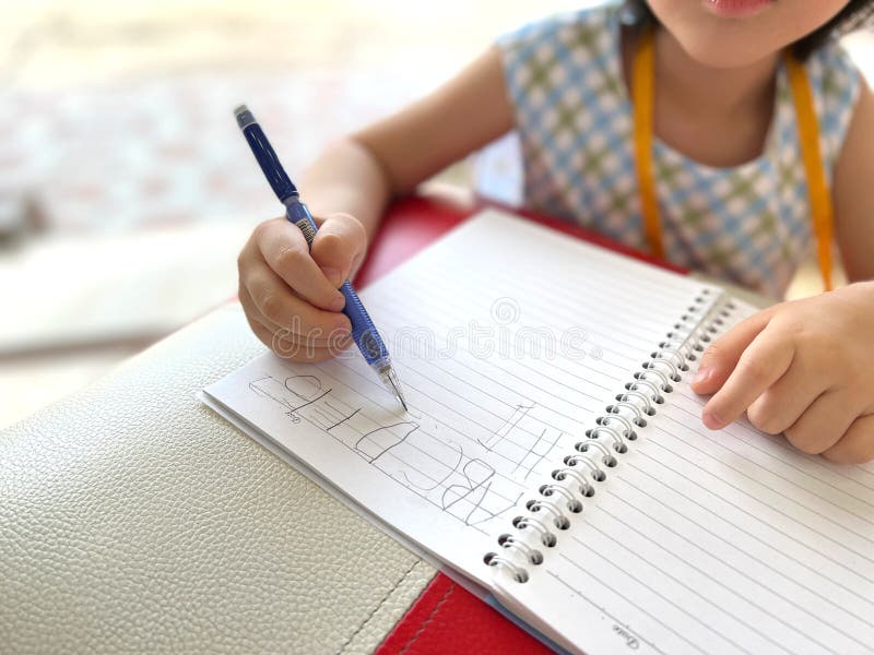Cute Little Girl Writes on Her Notebook Stock Photo - Image of design ...