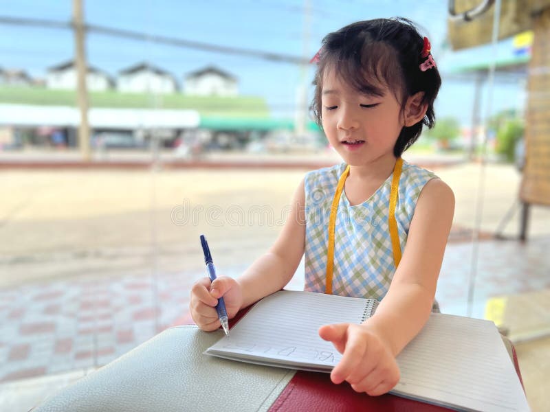Cute Little Girl Writes on Her Notebook Stock Photo - Image of ...