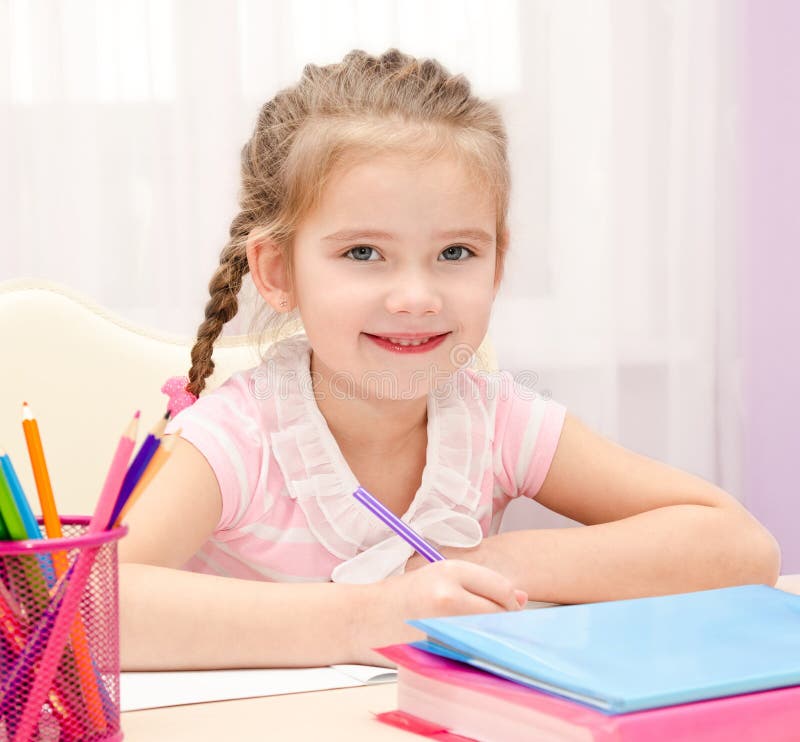Little Girl Writing at Desk in Classroom Stock Photo - Image of junior ...