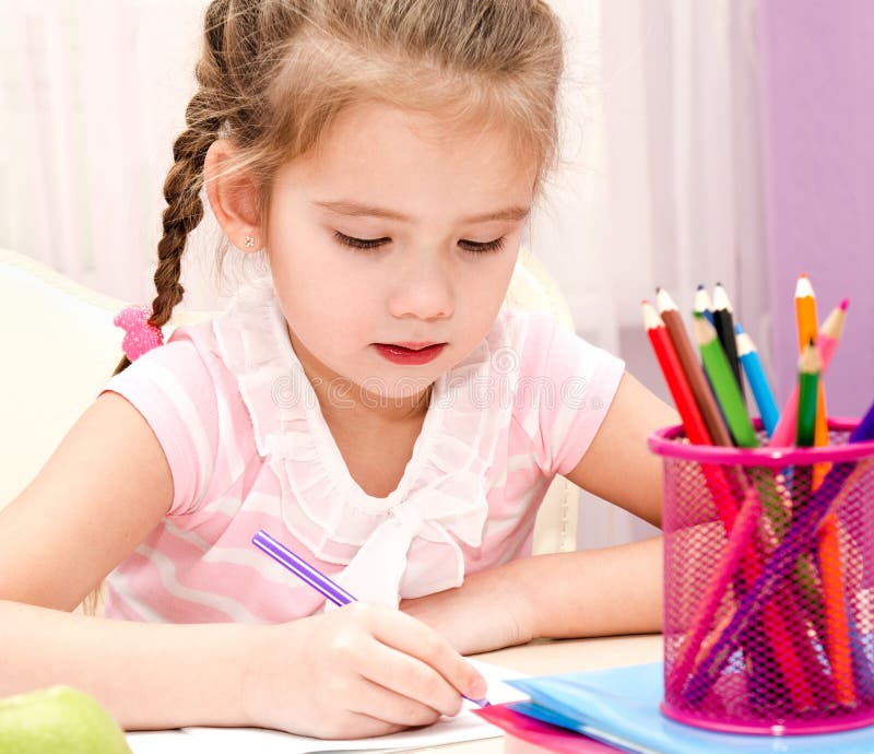 Cute Smiling Little Girl is Writing at the Desk Stock Photo - Image of ...