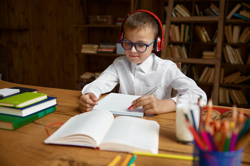 Cute Little Schoolboy Student in Headset Doing Language Homework at ...
