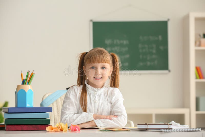 Cute Little Schoolgirl Sitting at Table in Classroom Stock Photo ...