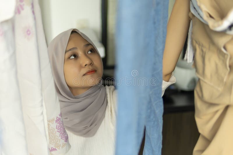 Cute Malay Woman Doing Routine Housework by Folding Her Laundry Stock ...