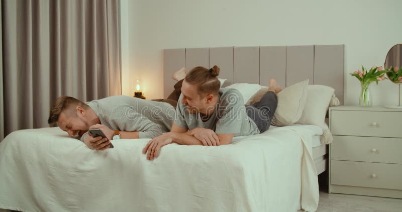 Cute Male Gay Couple Spend Time Lying Down Sofa Bed Use Smartphone Stock Footage Video Of