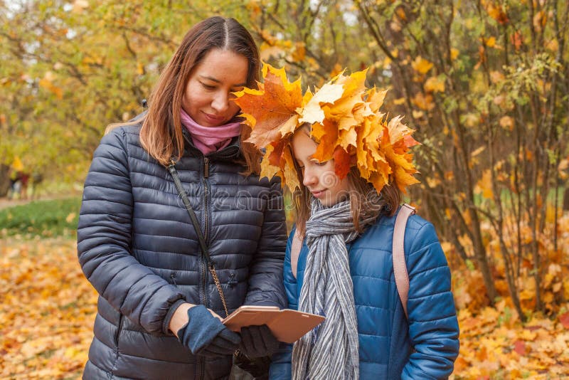 Cute Mother and Daughter with Smartphone on Autumn Day Stock Photo ...