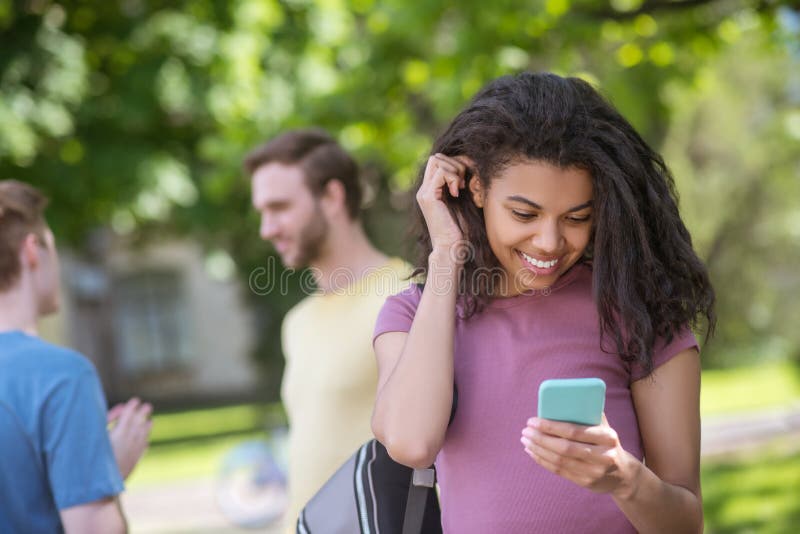 Cute Mulatta with a Smartphone Smiling Nicely Stock Photo - Image of ...