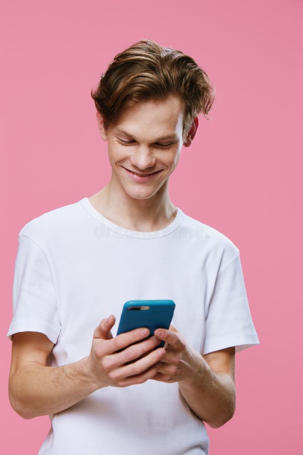 Cute Nice Guy with a Thoughtful Smile Typing a Text Message on the ...
