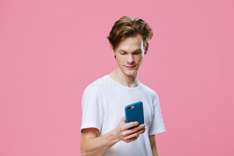 Cute Nice Guy with a Thoughtful Smile Typing a Text Message on the ...