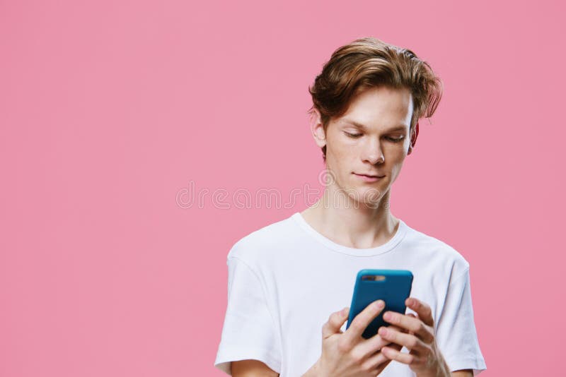 Cute Nice Guy with a Thoughtful Smile Typing a Text Message on the ...