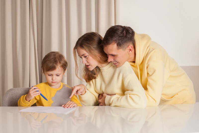 Cute Parents in Yellow Clothes with Their Child Son Sitting by the ...