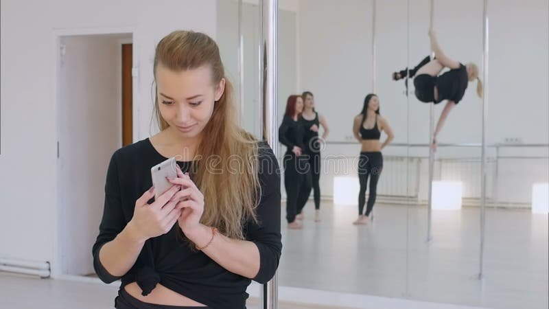 Cute Pole Dancer Using Cell Phone during a Pole Dance Class Stock Video ...