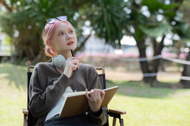 A Cute and Positive Asian Female Student is Writing a Diary or Writing ...