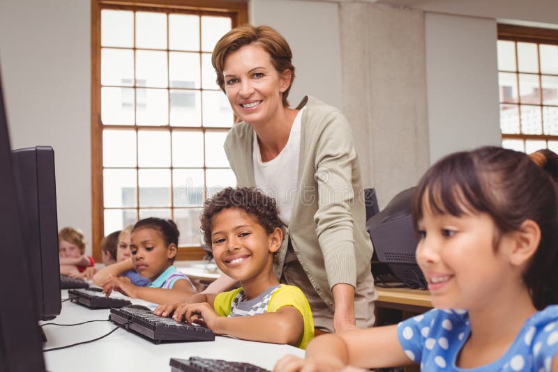 Cute Pupil in Computer Class with Teacher Smiling at Camera Stock Photo ...