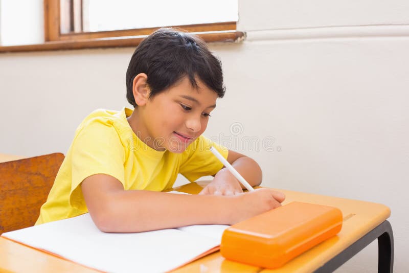 Cute Pupil Writing at Desk in Classroom Stock Image - Image of child ...