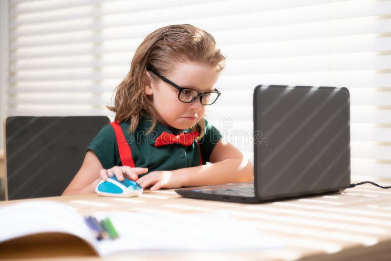 Cute Pupil Writing at Notebook in Classroom at the Elementary School ...