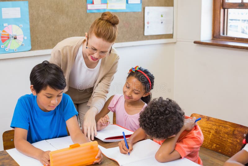 Cute Pupils Getting Help from Teacher in Classroom Stock Photo - Image ...