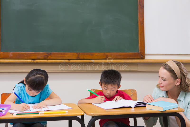 Cute Pupils Getting Help from Teacher in Classroom Stock Photo - Image ...