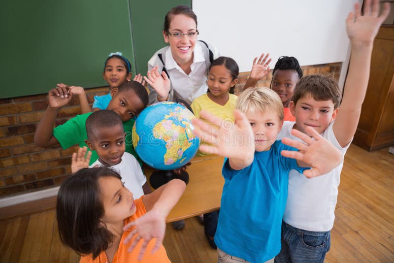Cute Pupils Smiling Around a Globe in Classroom with Teacher Stock ...