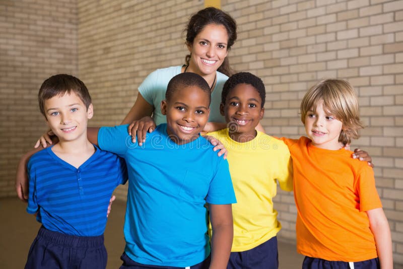 Cute Pupils Smiling at Camera with PE Teacher Stock Photo - Image of ...