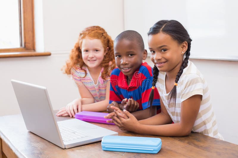 Cute pupils using computer stock image. Image of desk - 50495837