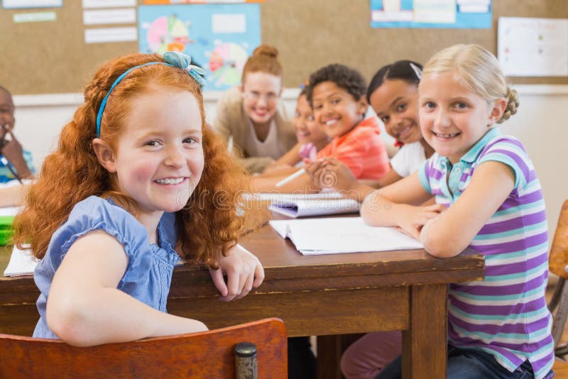 Cute Pupils Writing at Desk in Classroom Stock Photo - Image of learn ...