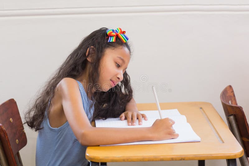Cute Pupils Writing at Desk in Classroom Stock Photo - Image of ...