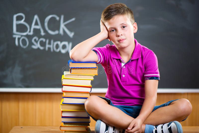 Cute School Boy Sitting with Books in Classroom Stock Photo - Image of ...