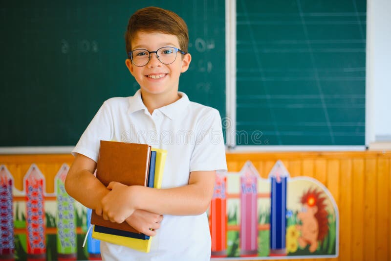 Cute Schoolboy Near Blackboard in Classroom Stock Photo - Image of ...