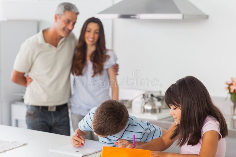 Cute Siblings Drawing Together in Kitchen with Their Parents Smiling ...