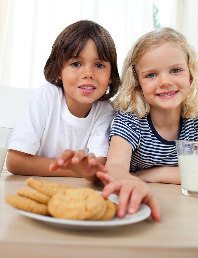 Cute Siblings Eating Biscuits Stock Photo - Image of happy, home: 12617628