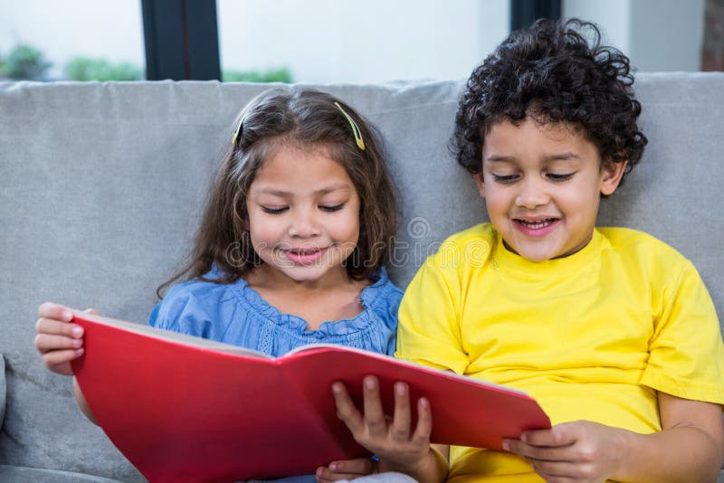 Cute Siblings Reading a Book on the Sofa Stock Photo - Image of happy ...