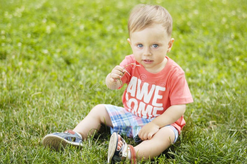 Cute small boy on grass stock photo. Image of relaxing - 41661766