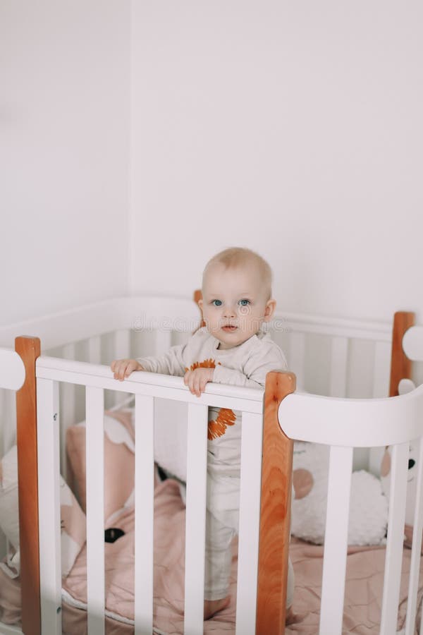 Cute Little Baby Standing in Crib at Home. Stock Photo - Image of ...