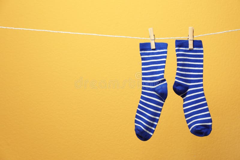 Cute Socks on Laundry Line Against Color Background. Stock Photo ...