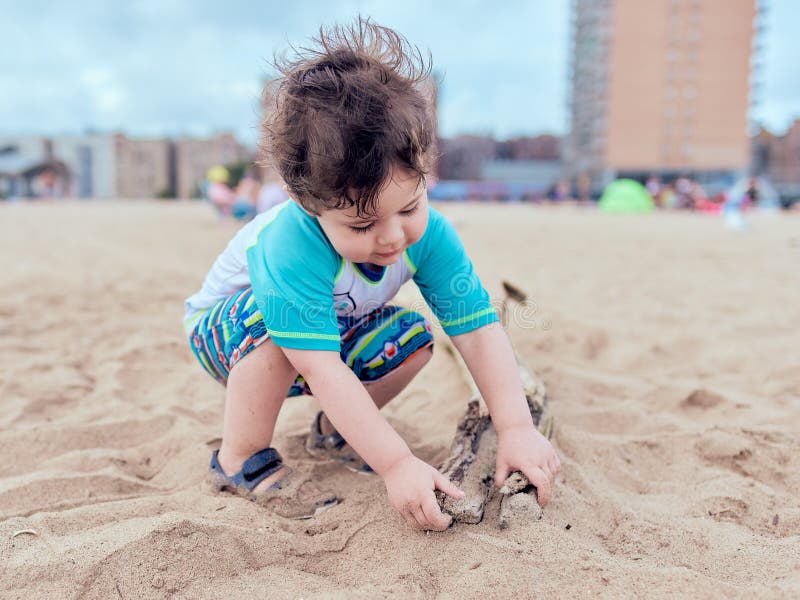 Cute Toddler Playing on the Beach and Trying To Move the Log Stock ...