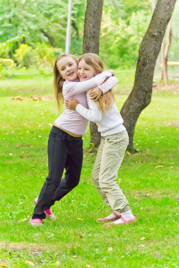 Cute two embracing girls stock image. Image of action - 52605601