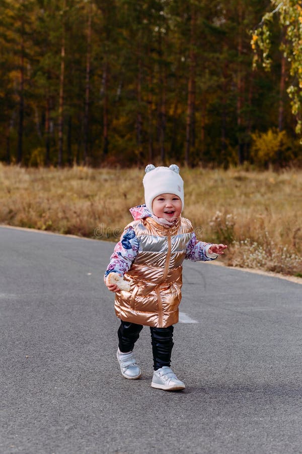 Cute Two-year-old Baby in a White Hat and Gold Vest in the Fall on a ...