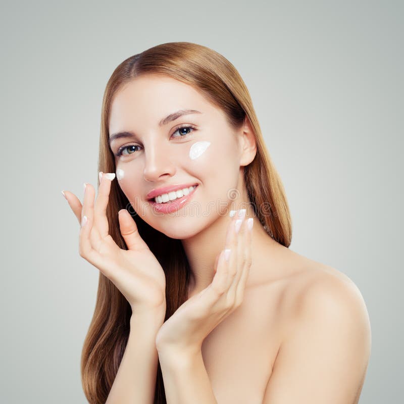 Cute Woman Applying Cream On Healthy Skin And Smiling Facial Treatment