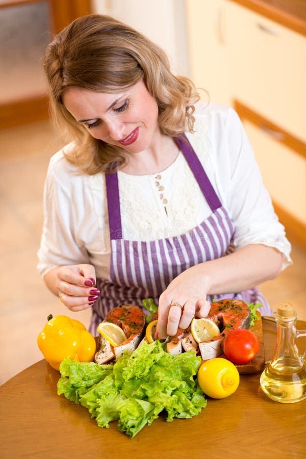 Cute Woman Preparing Fish in Kitchen Stock Photo - Image of cooker ...